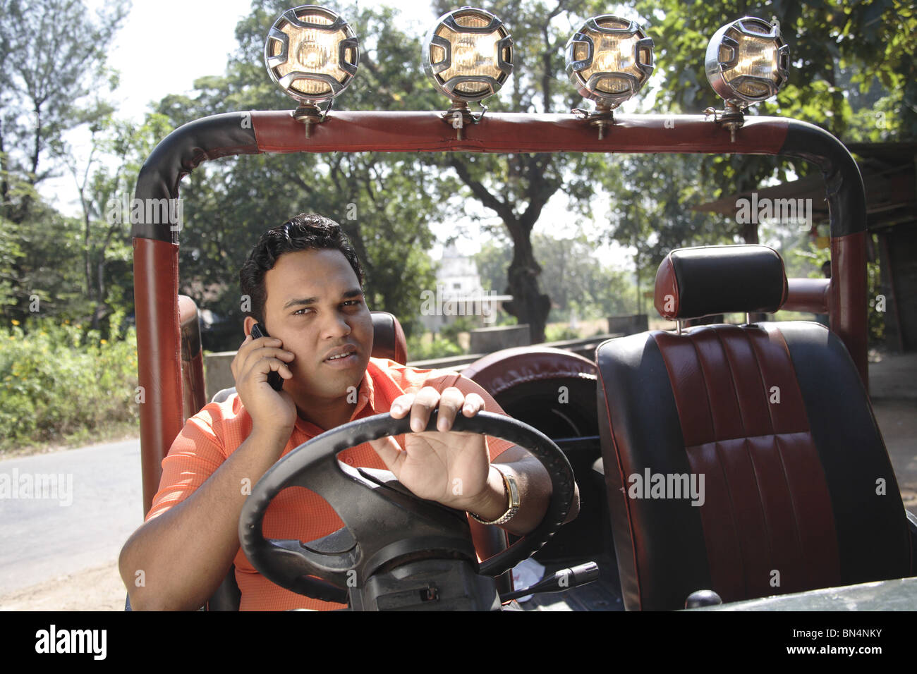 South Asian Indian young man sitting on driver's seat in India jeep and ...