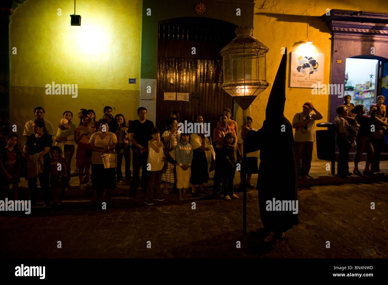 People look at one pointed hat penitent during holy week celebrations ...