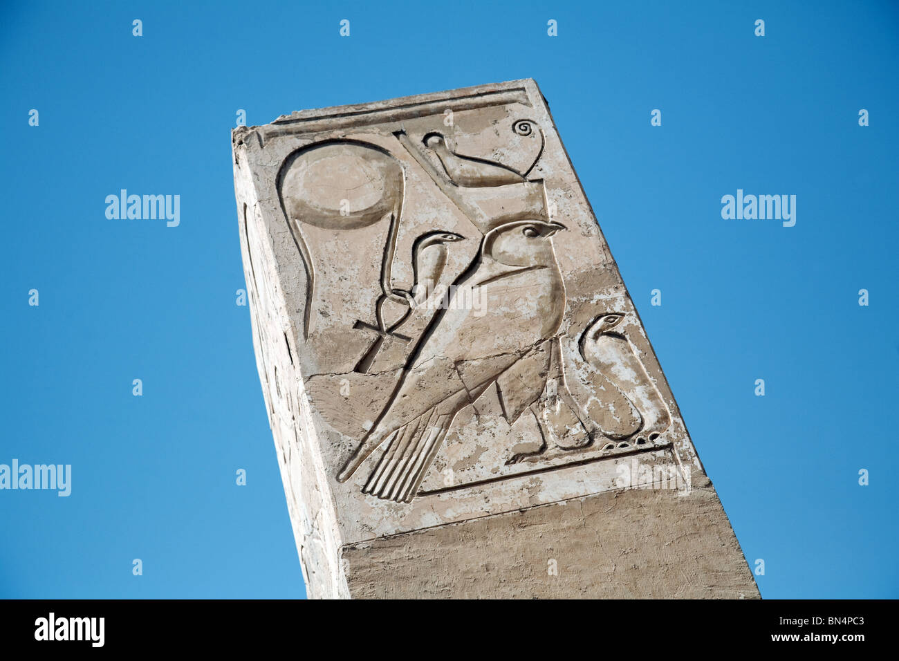A column with bas relief carvings seen against a blue sky; the mortuary ...