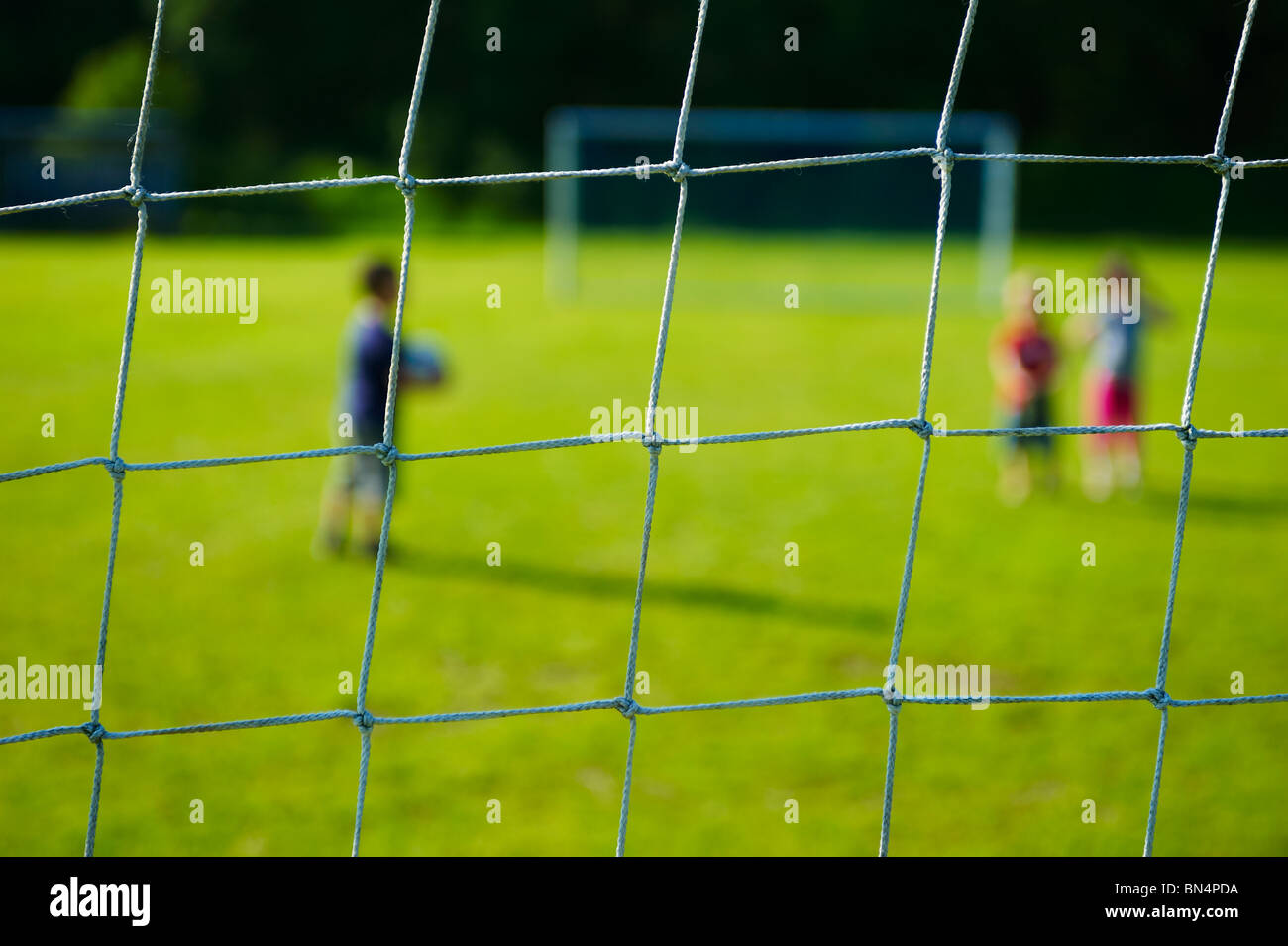 Children playing football on field Stock Photo - Alamy