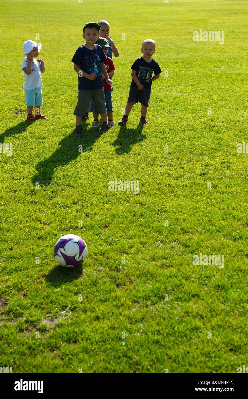 Children playing football on field Stock Photo - Alamy