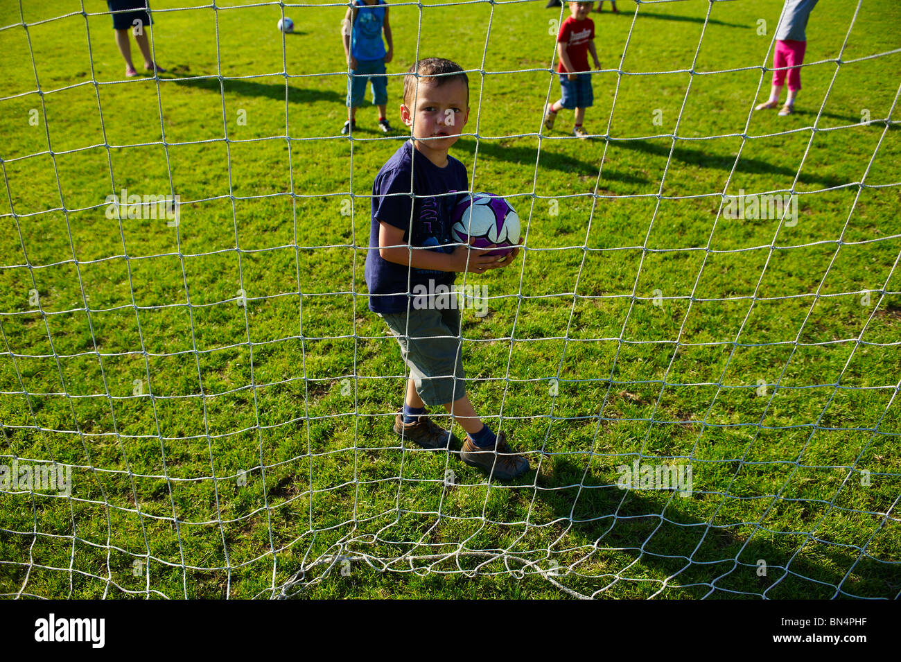 Children playing football on field Stock Photo - Alamy