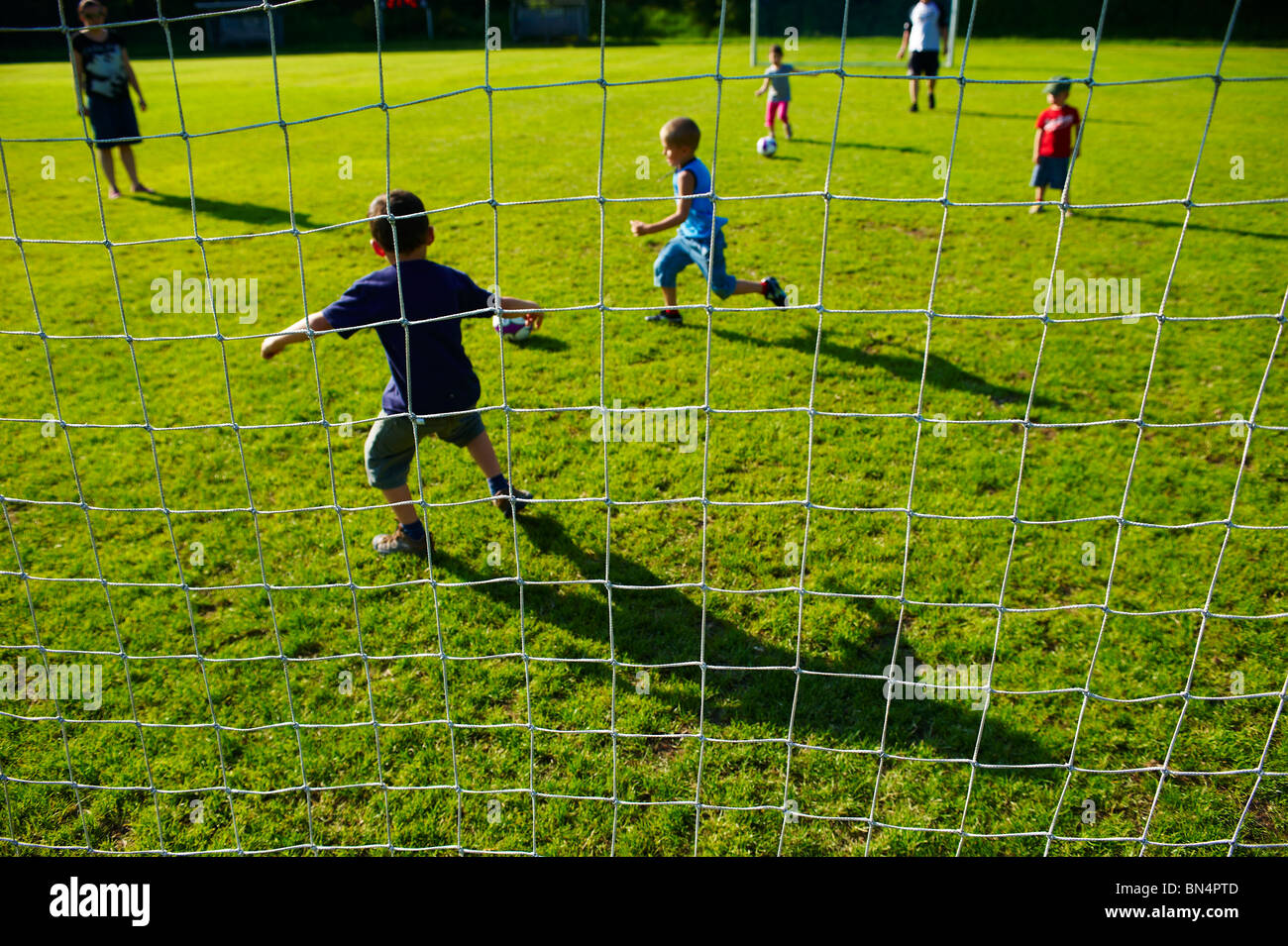 Children playing football on field Stock Photo - Alamy