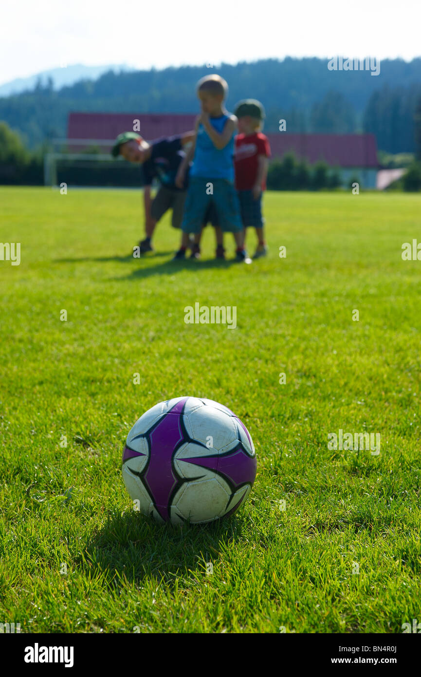 Children playing football on field Stock Photo - Alamy