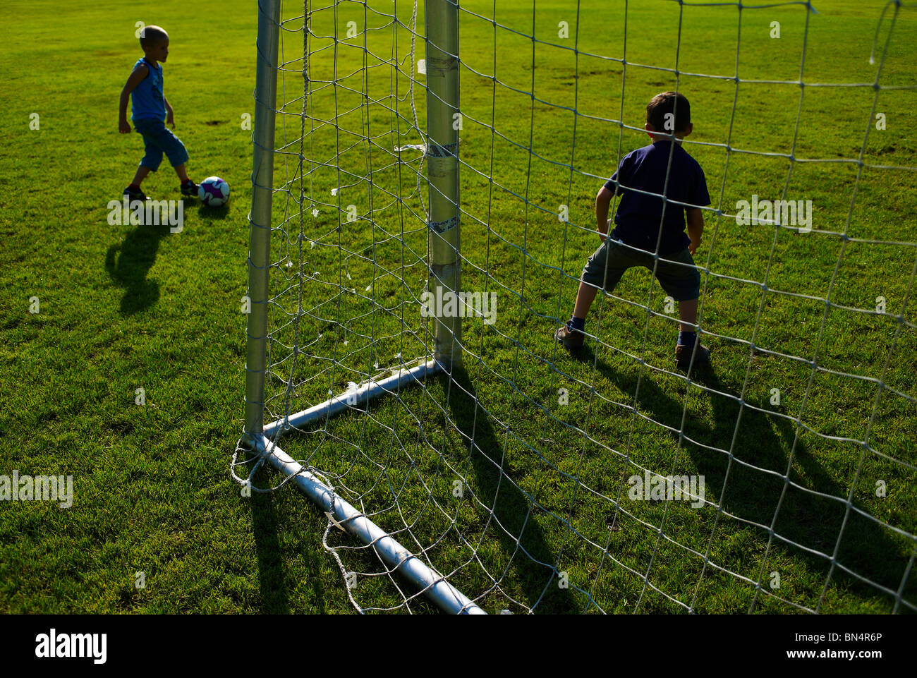 Children playing football on field Stock Photo - Alamy