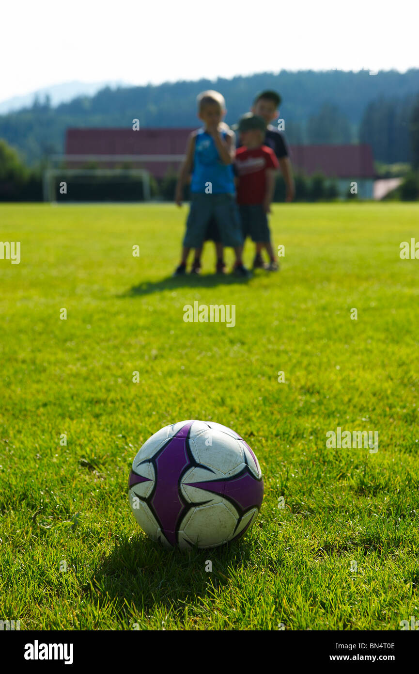 Children playing football on field Stock Photo - Alamy