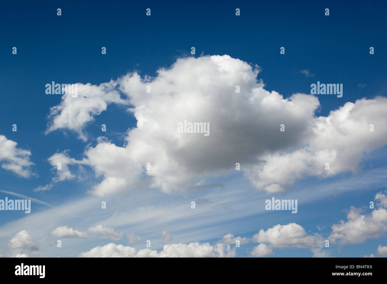 Weather small fluffy white cumulus clouds below cirrus in blue sky on ...