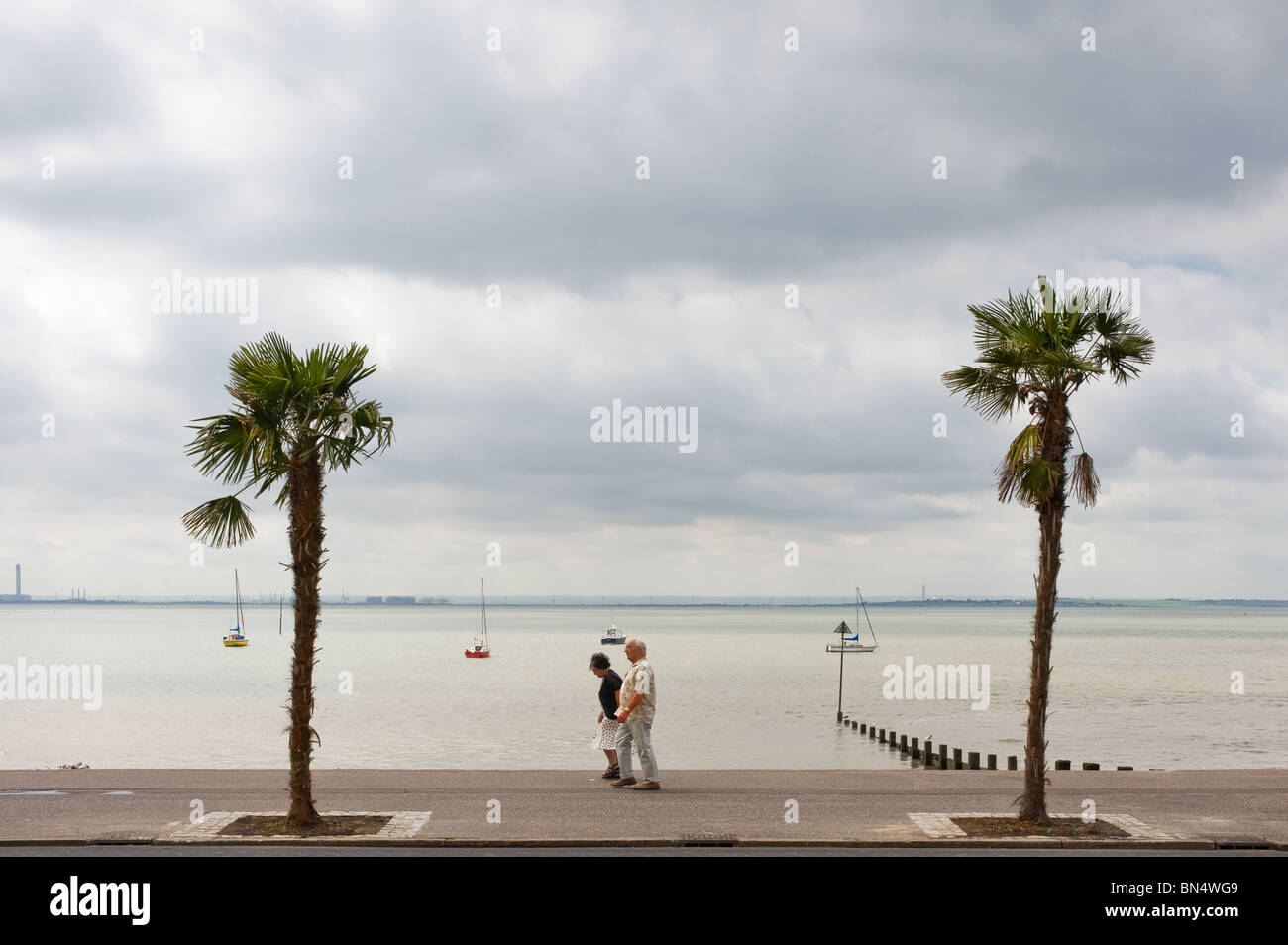 Seafront two people walking couple retired retirement strolling hi-res ...