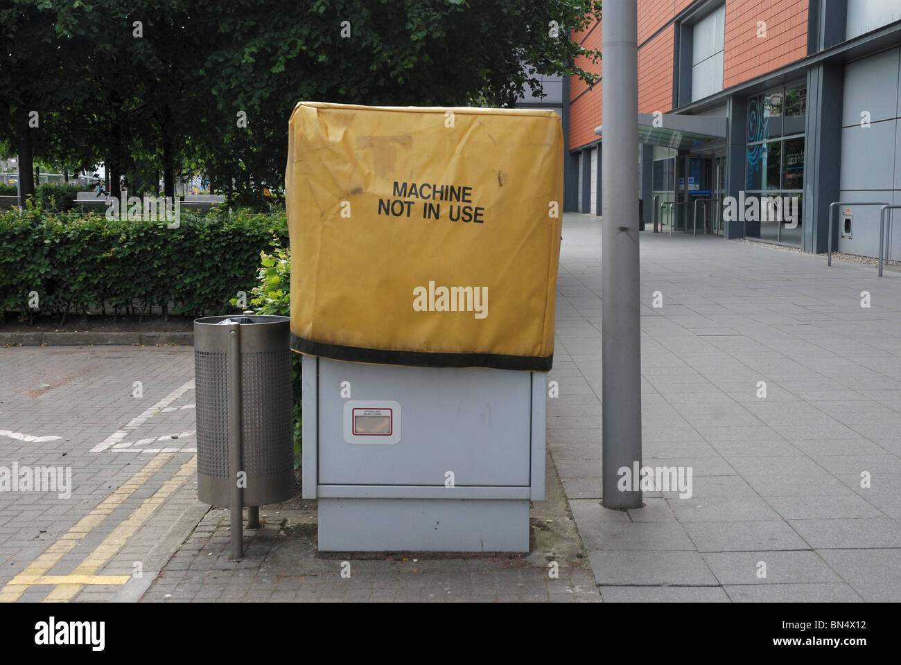 Parking ticket machine with a yellow cover bearing the words "machine ...