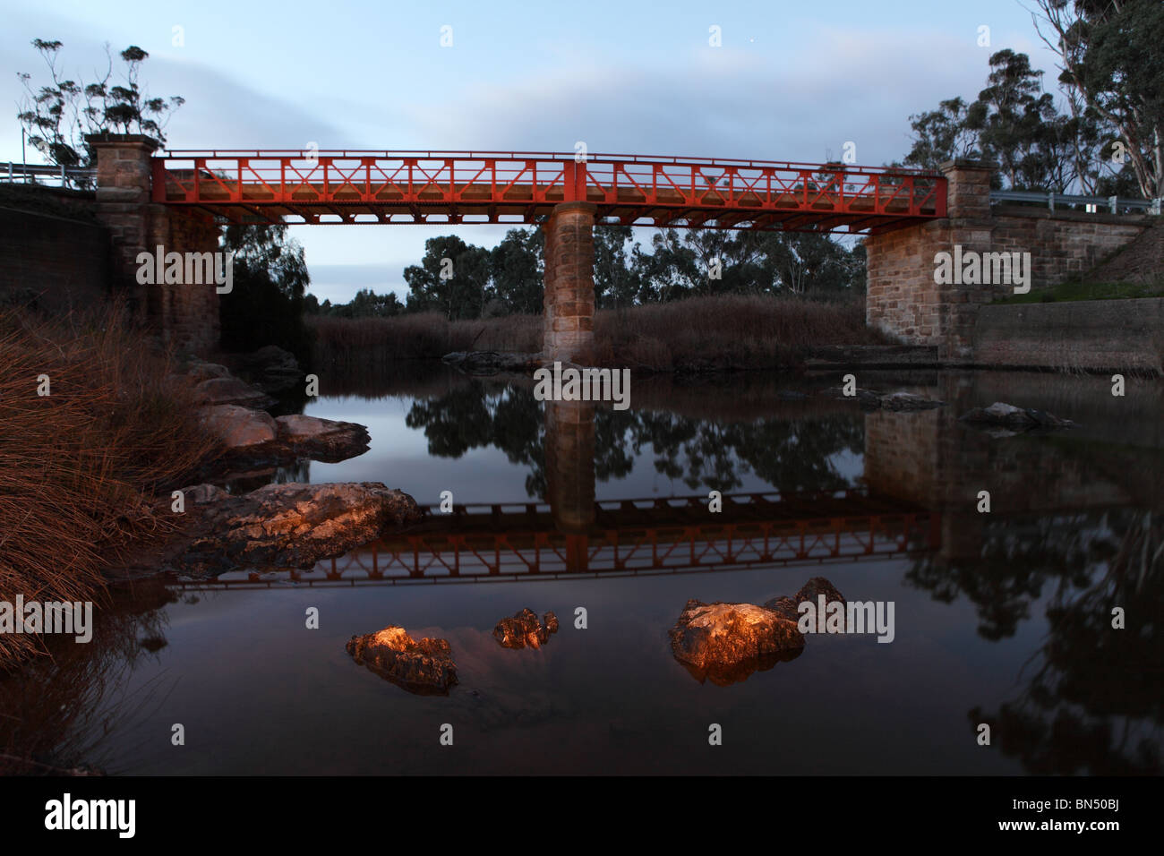 Landscape images of a bridge over a river with rocks protruding from ...