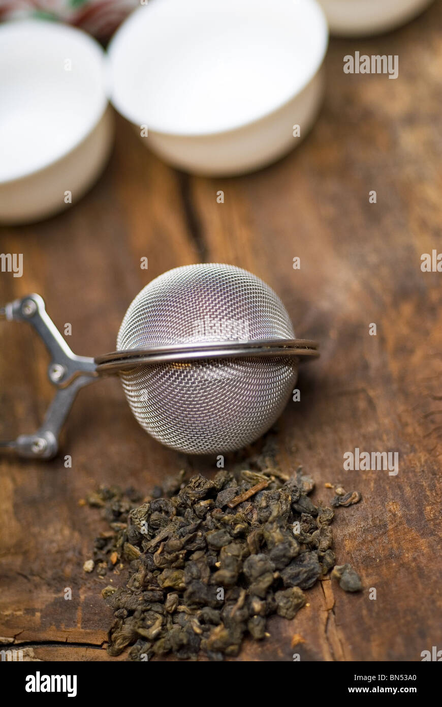 dry green chinese tea set,with strainer closeup,cups and teapot on ...