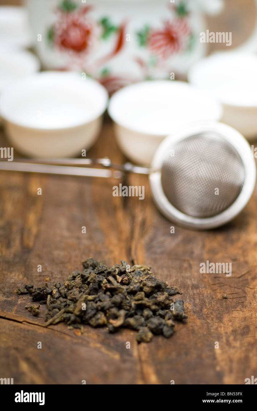dry green chinese tea set,with strainer closeup,cups and teapot on ...