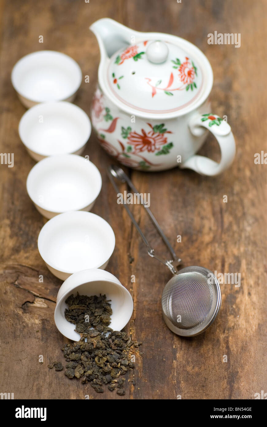 dry green chinese tea set,with strainer closeup,cups and teapot on ...