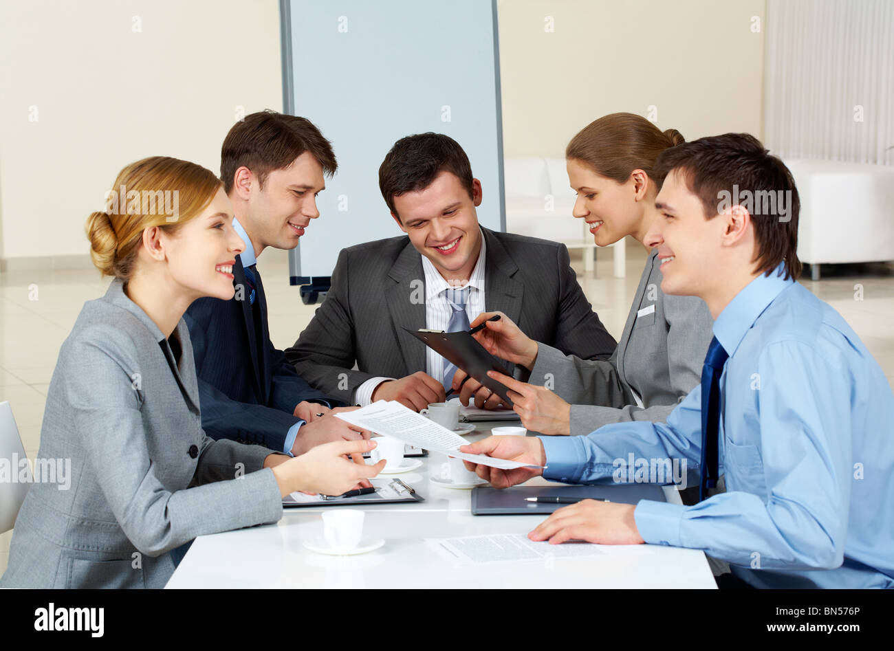 Portrait of friendly colleagues looking at each other while confident ...