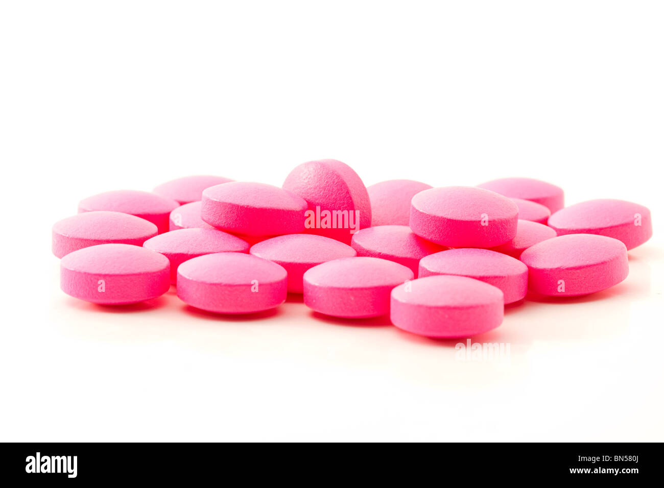 some pink painkiller pills on white background Stock Photo - Alamy