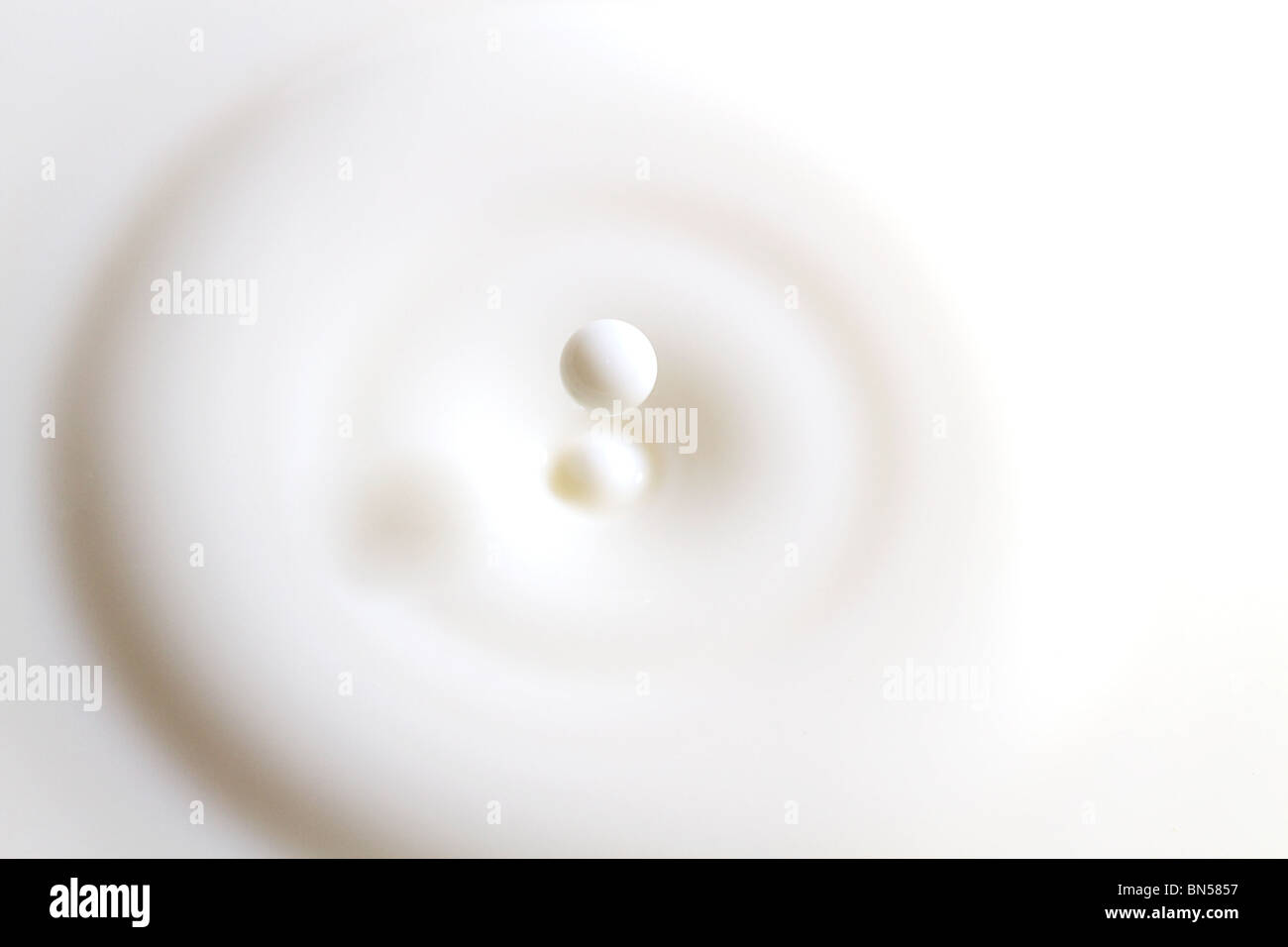 a drop of milk falls into a plate of milk Stock Photo - Alamy