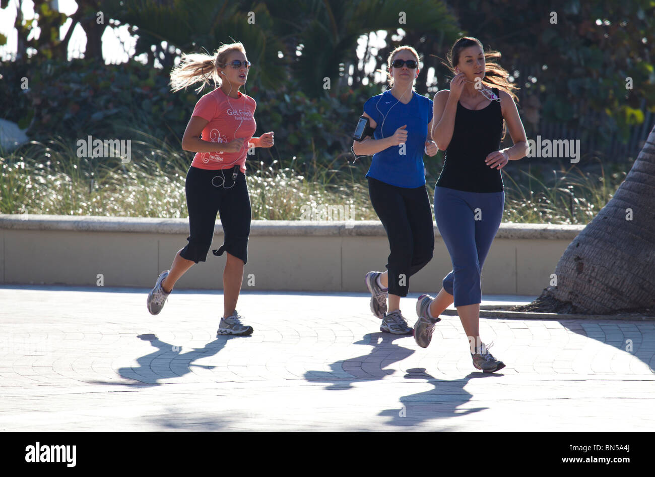Three young pretty girls jogging along Miami South Beach Stock Photo ...