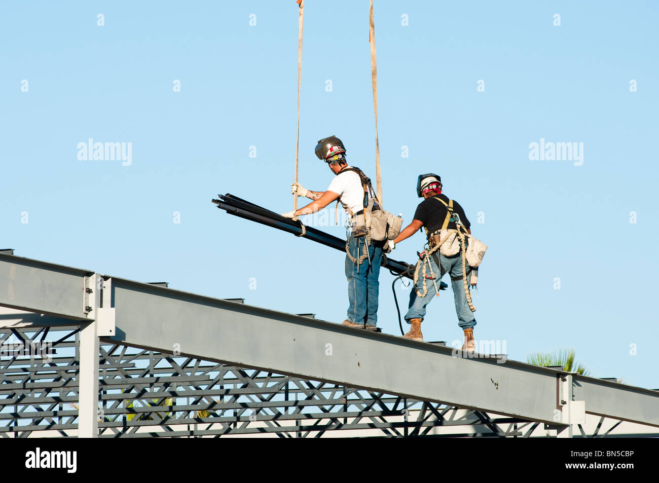 steelworkers erect the structural steel framework for a commercial ...