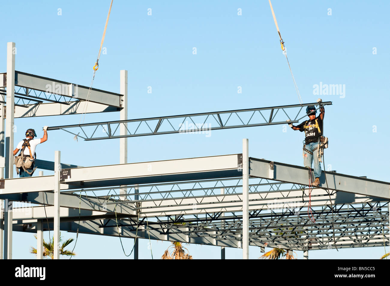 steelworkers erect the structural steel framework for a commercial ...