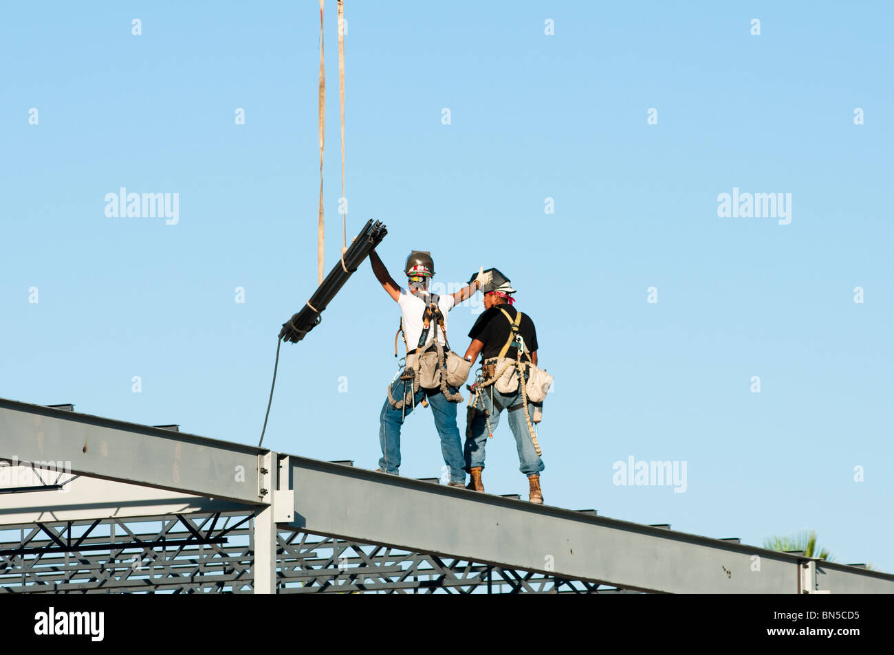 steelworkers erect the structural steel framework for a commercial ...