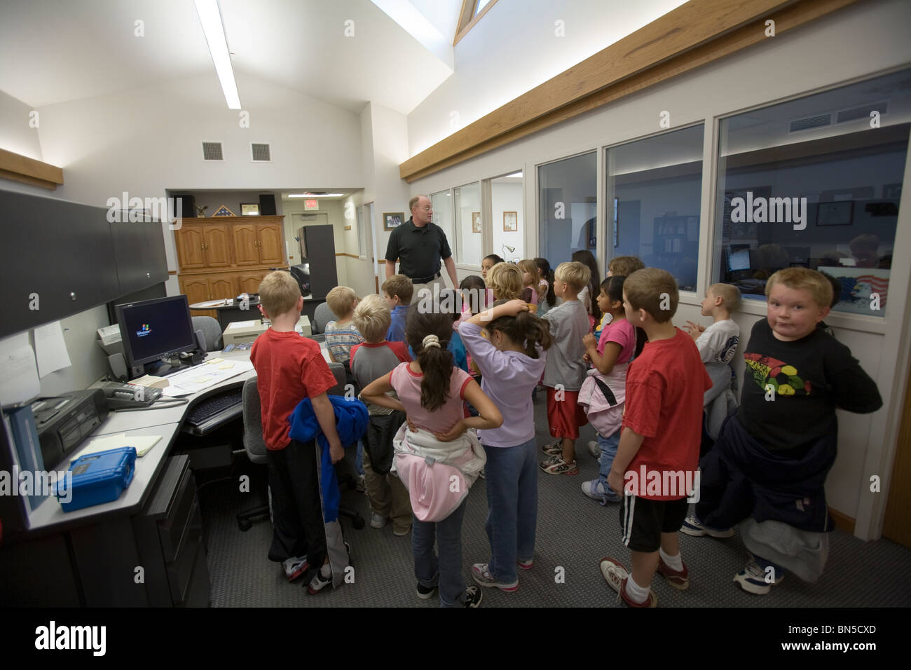 School children visiting small town police department. Young kids with ...