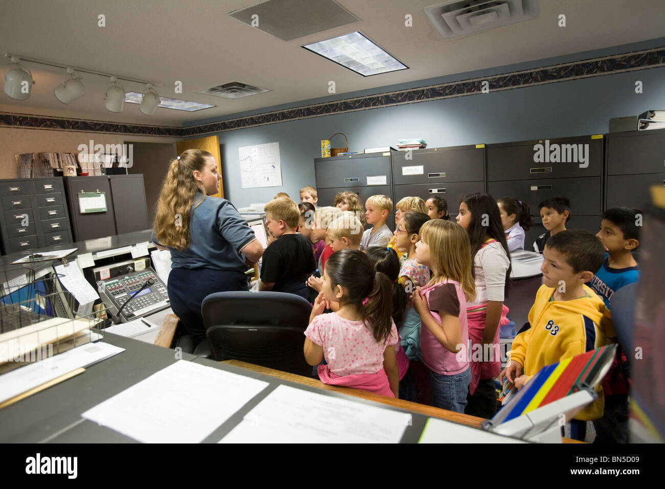 School children visiting small town police department. Young kids with ...