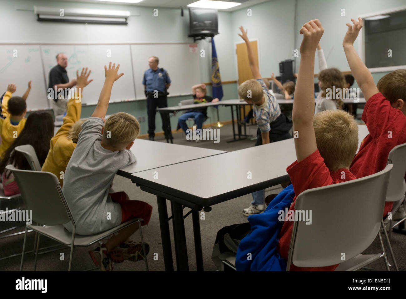 School children visiting small town police department. Young kids with ...