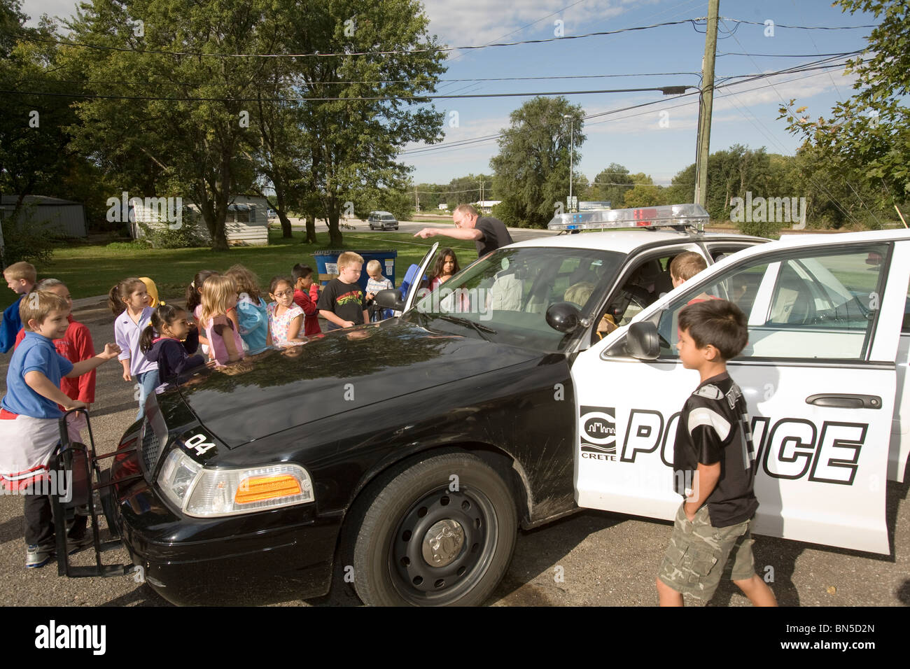 School children visiting small town police department. Young kids with ...