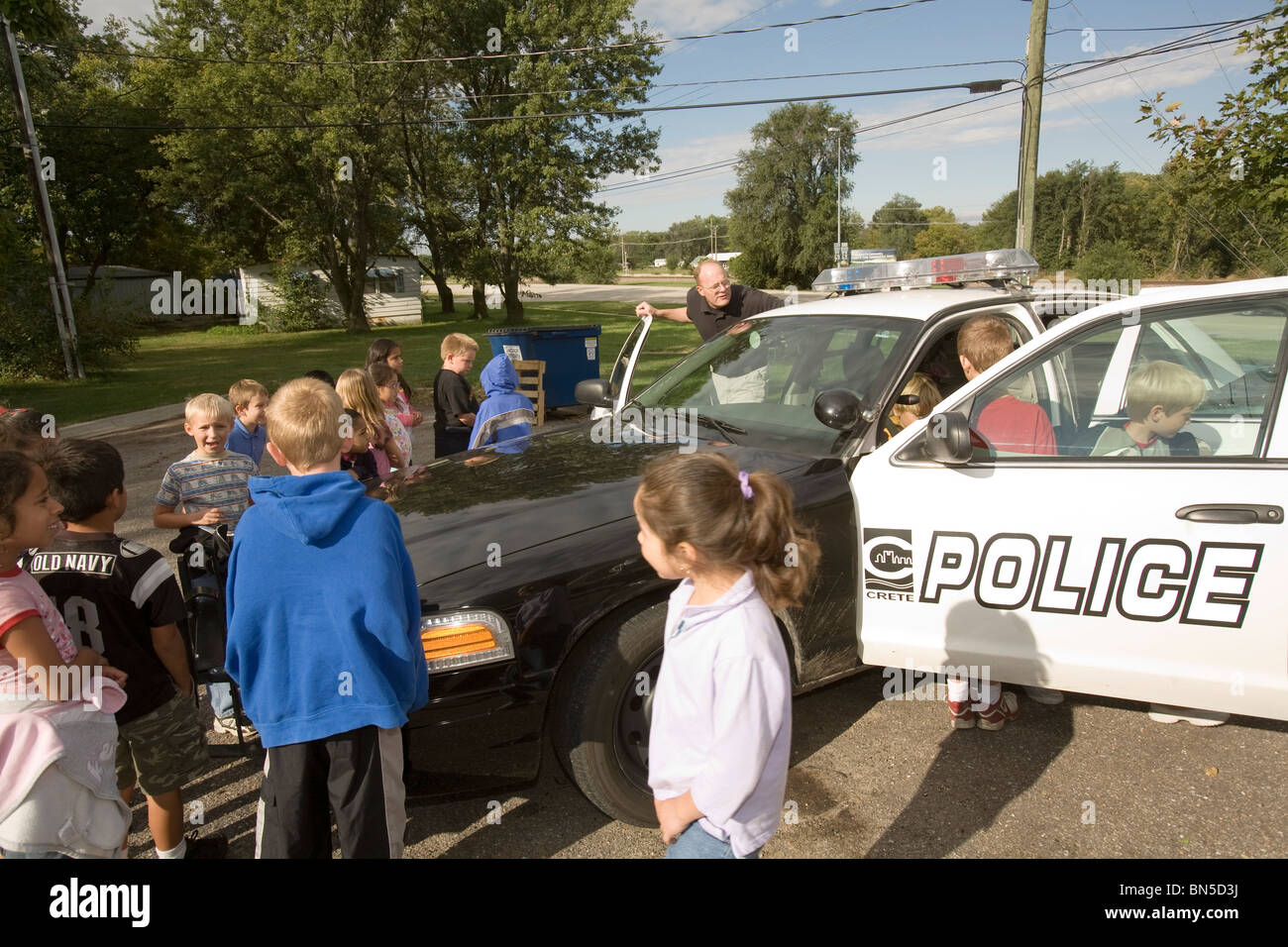 School children visiting small town police department. Young kids with ...