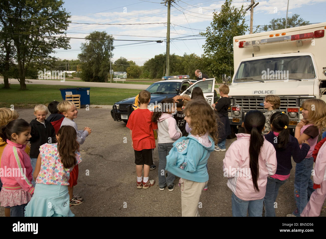 School children visiting small town police department. Young kids with ...