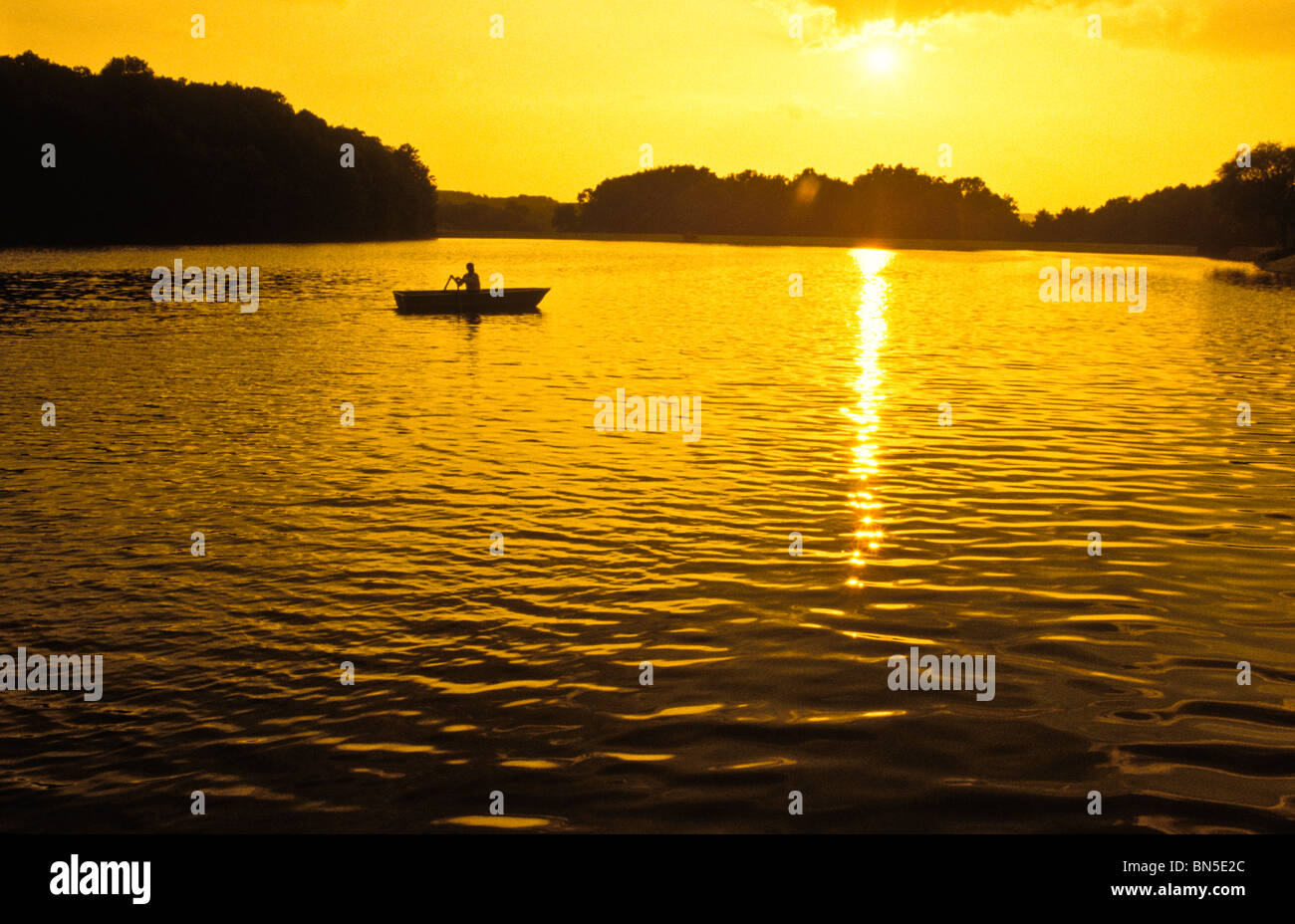 Fisherman in boat early morning, late afternoon Stock Photo - Alamy