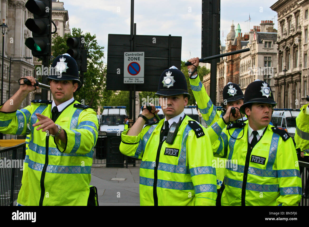 Police raise their batons to protesters during a visit by former U.S ...