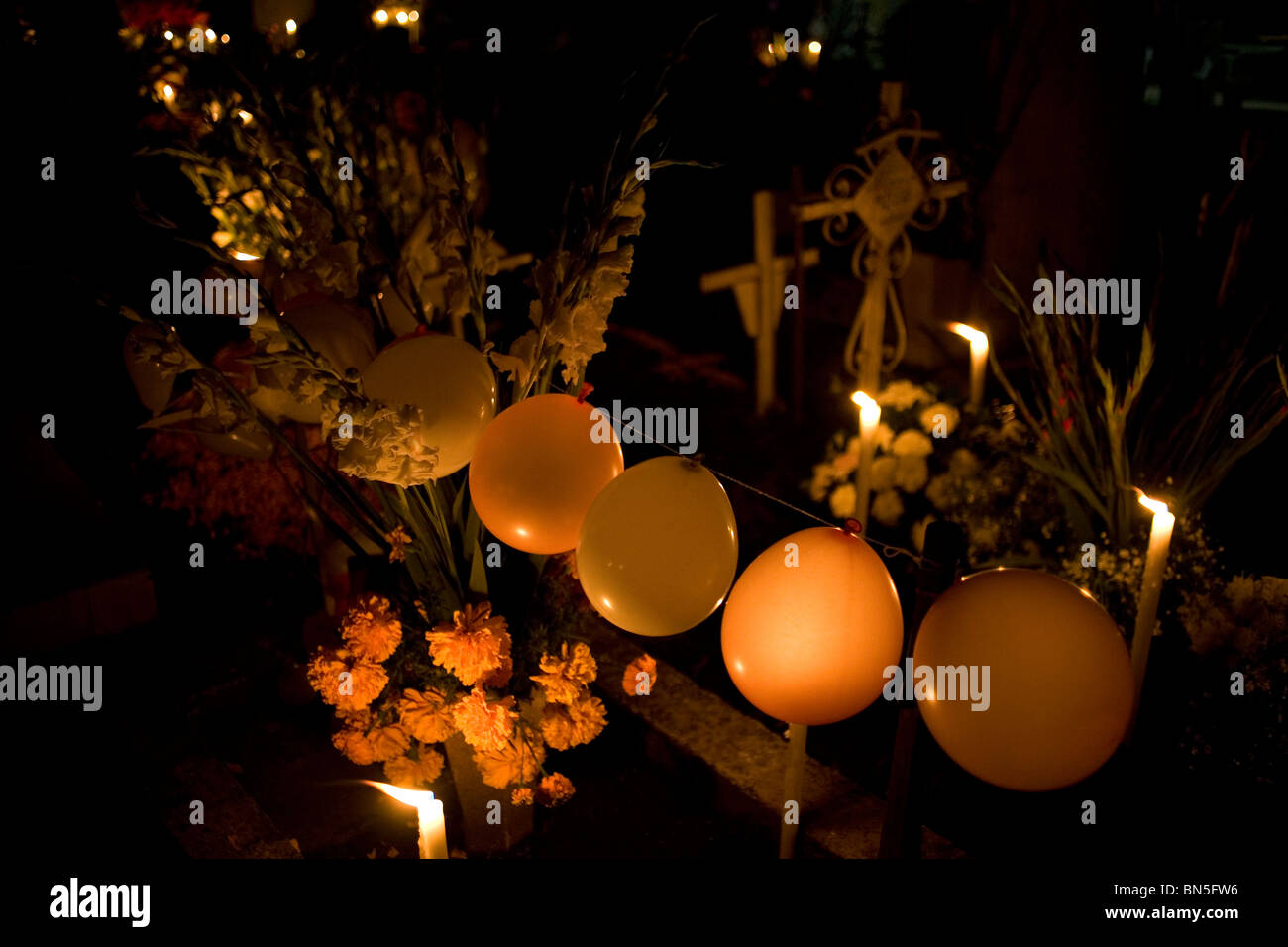 Balloons decorate the grave of a family member in a cemetery in San ...