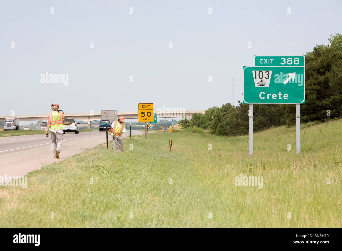 Prison inmates working on the side of the road to cut weeds, trim grass ...
