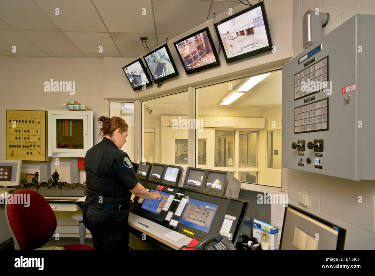 A uniformed female Hispanic corrections officer operates the electronic ...