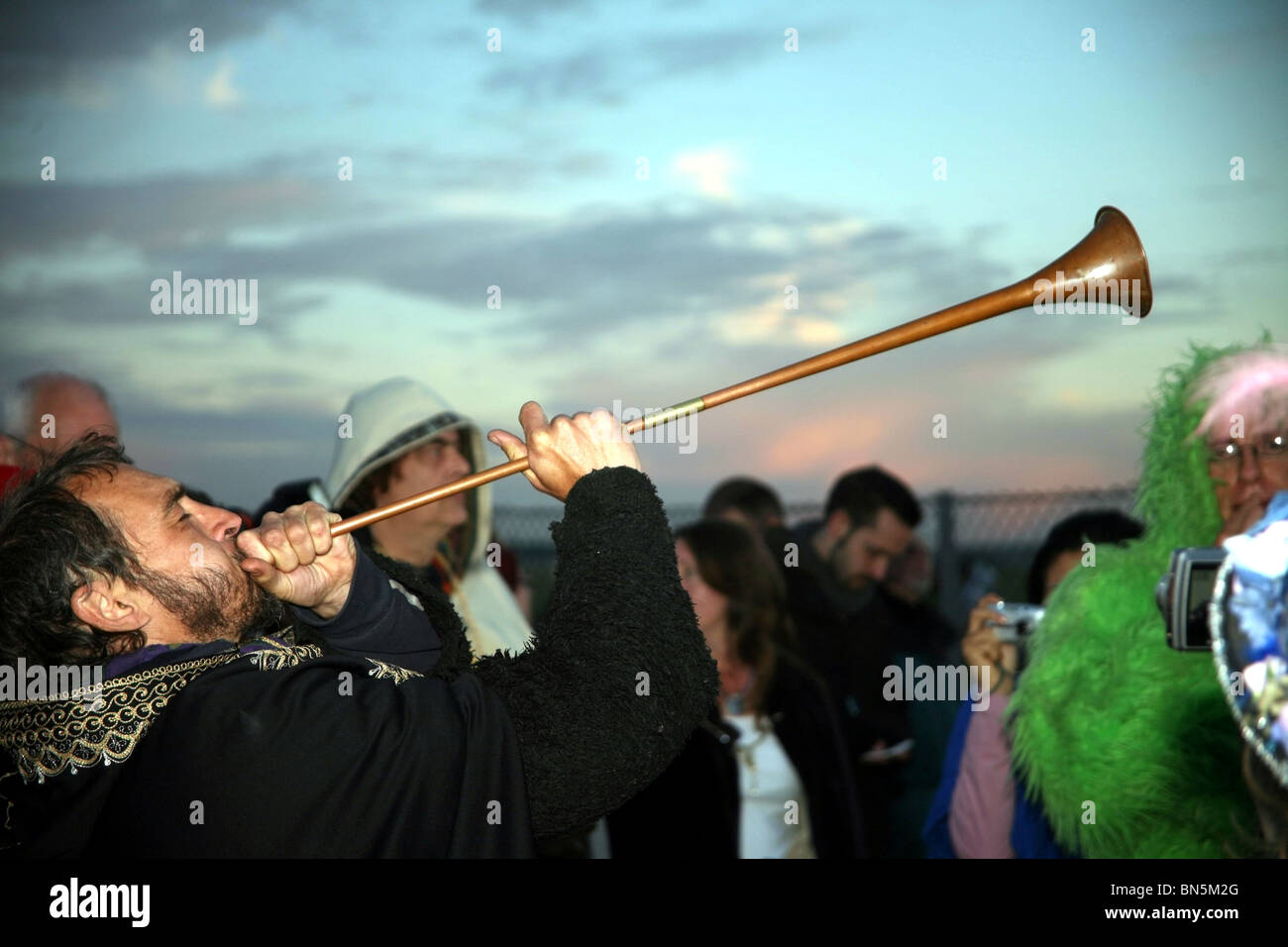 Playing a musical instrument trumpet, summer solstice at Stonehenge ...