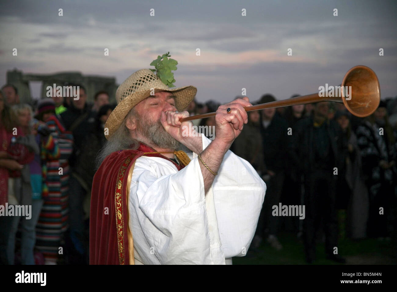 Playing a musical instrument trumpet, summer solstice at Stonehenge ...