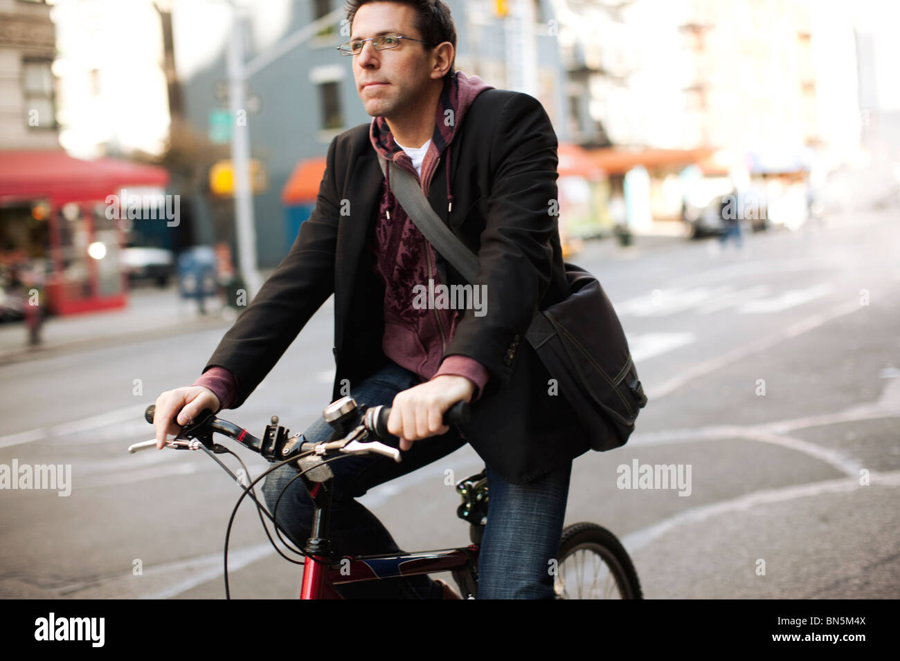 Caucasian man riding bicycle on urban street Stock Photo - Alamy