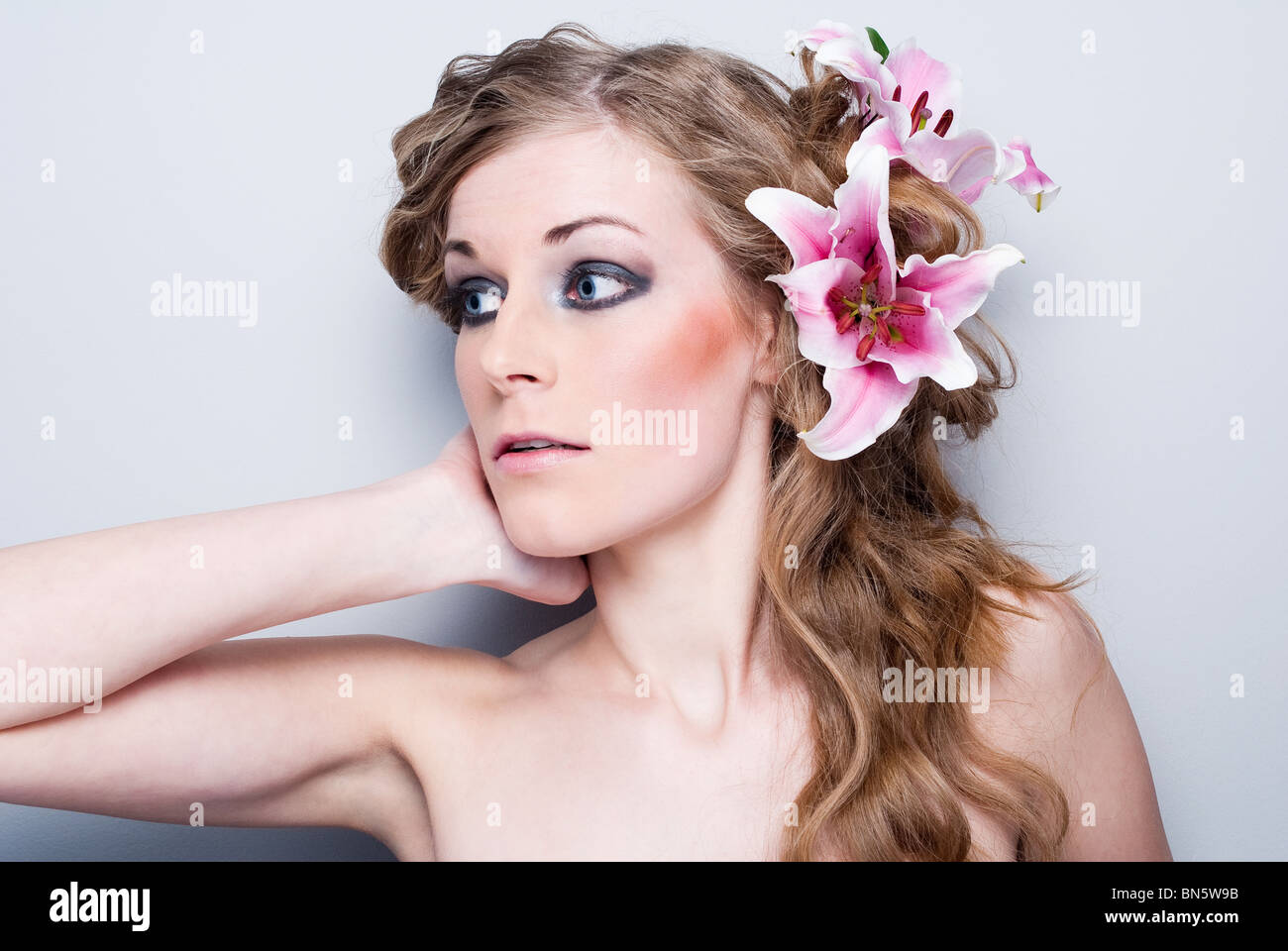 Pretty beautiful woman face with health skin and white lily in her ...