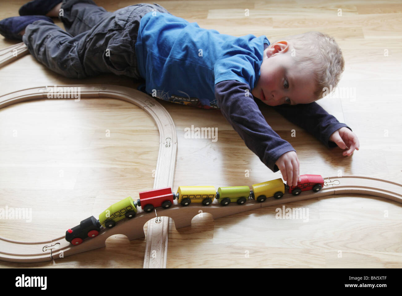 Toddler boy playing with a traditional wooden train set at home MODEL ...