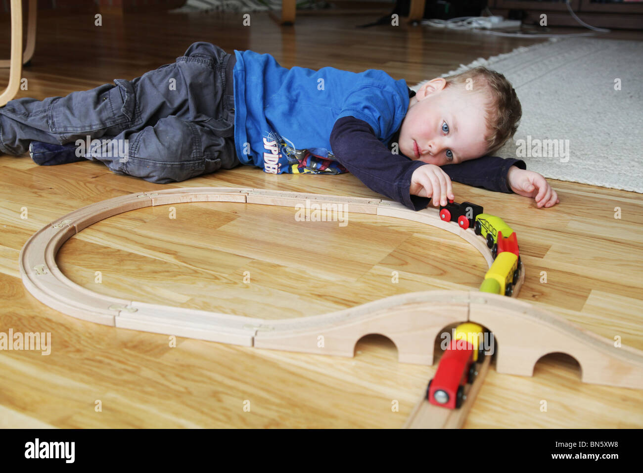 Toddler boy playing with a traditional wooden train set at home MODEL ...