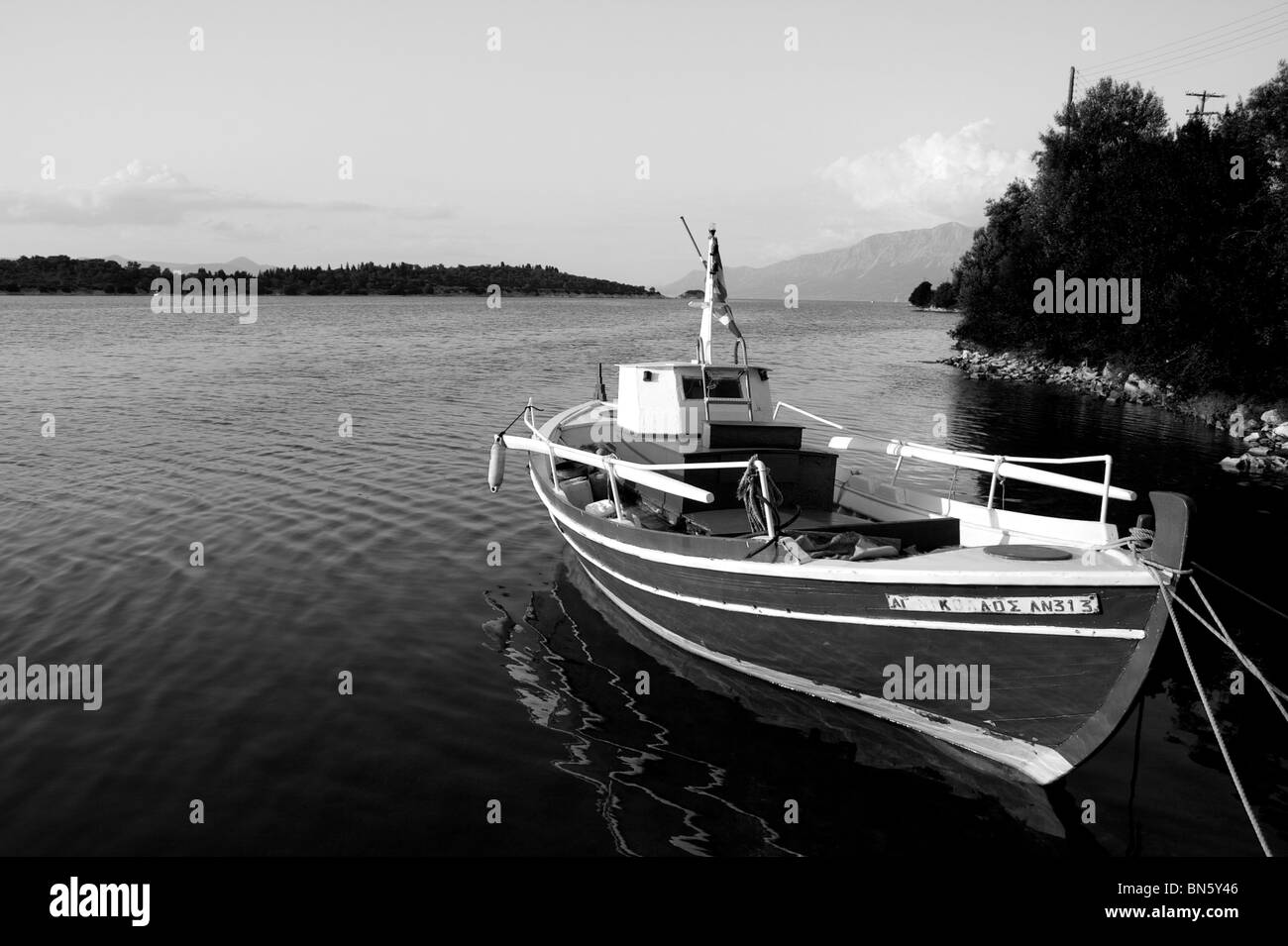 Local fishing boat in beautiful sea with a backdrop of mountains Stock ...