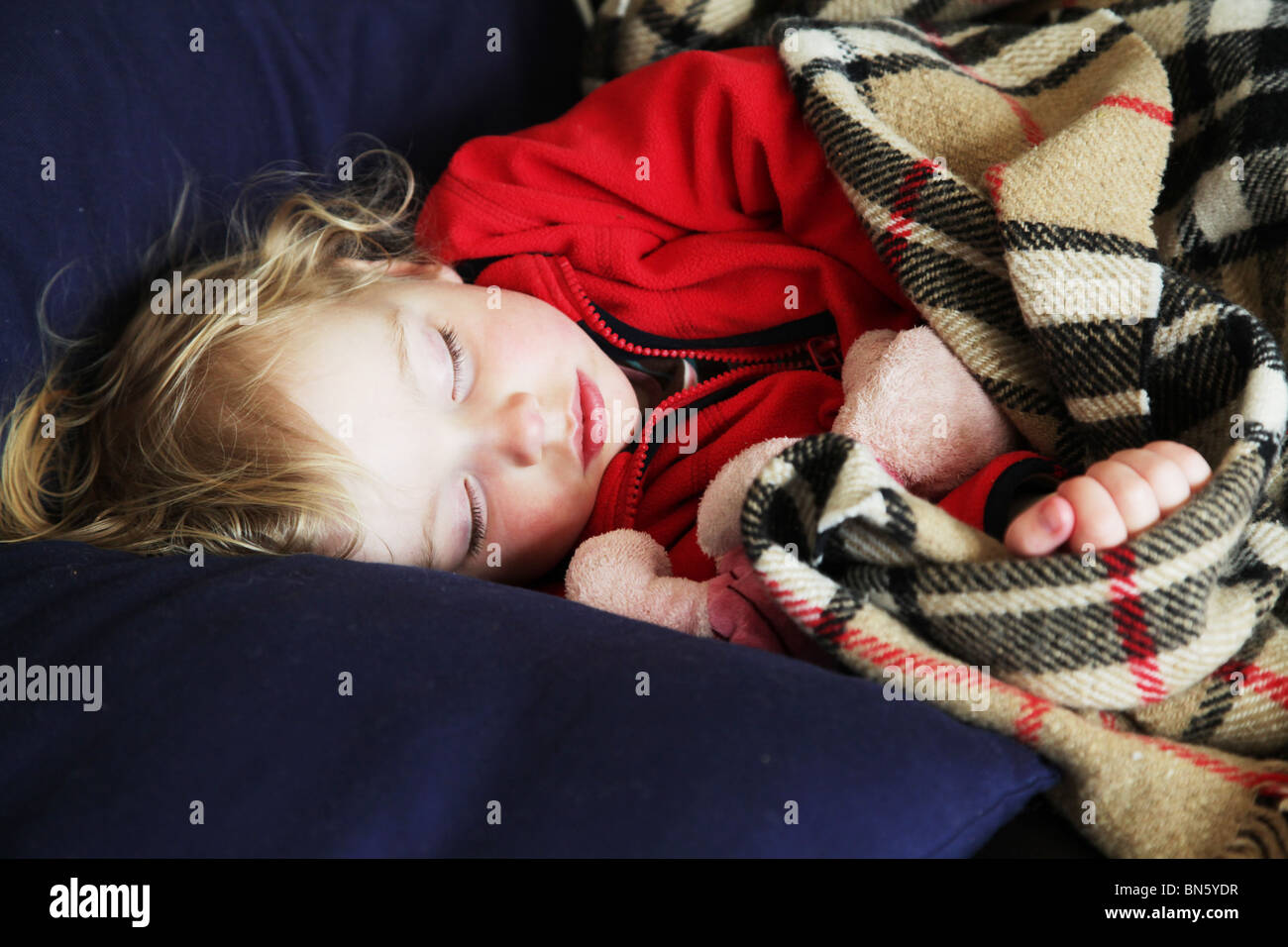 Toddler child girl sleeping taking a nap in the afternoon on a sofa ...