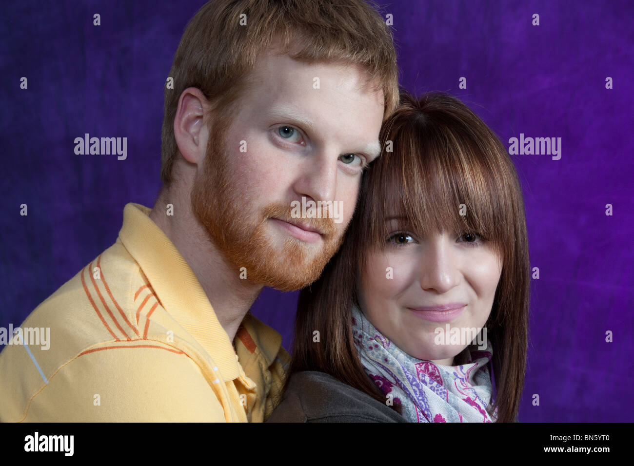 Serious couple in studio standing cheek to cheek Stock Photo - Alamy