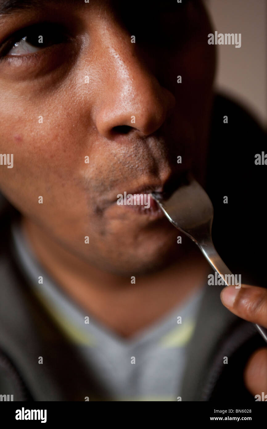 Young man eating Stock Photo - Alamy
