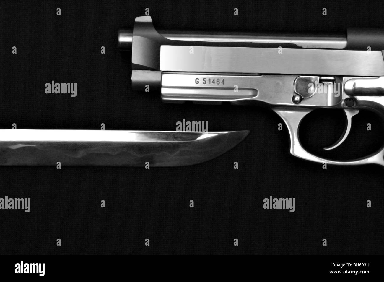 A black and white image of a sword underneath a pistol Stock Photo - Alamy