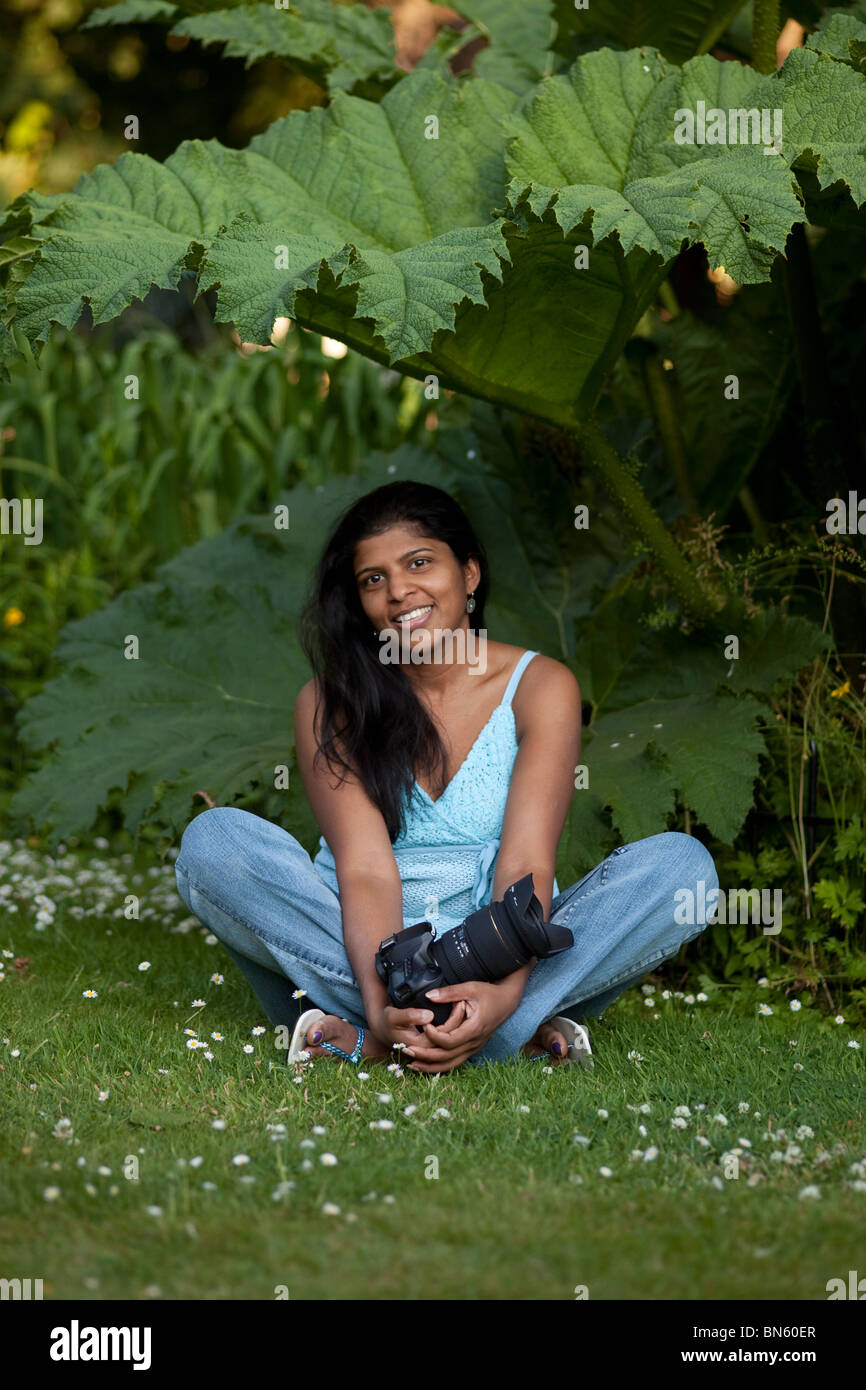 Female model with camera under a tree Stock Photo - Alamy
