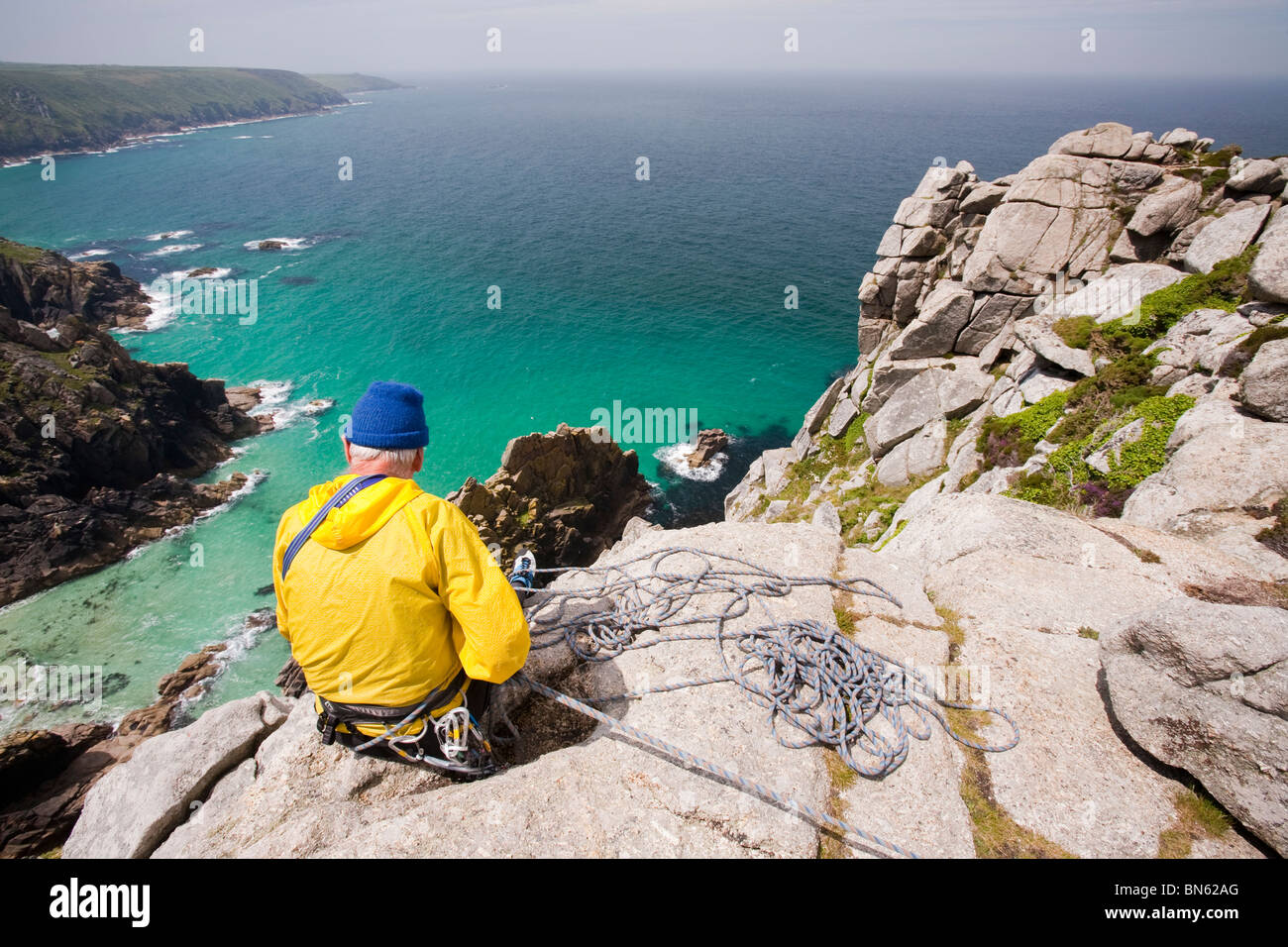 A couple in their 70's climbing on a granite sea cliff at Bosigran on ...