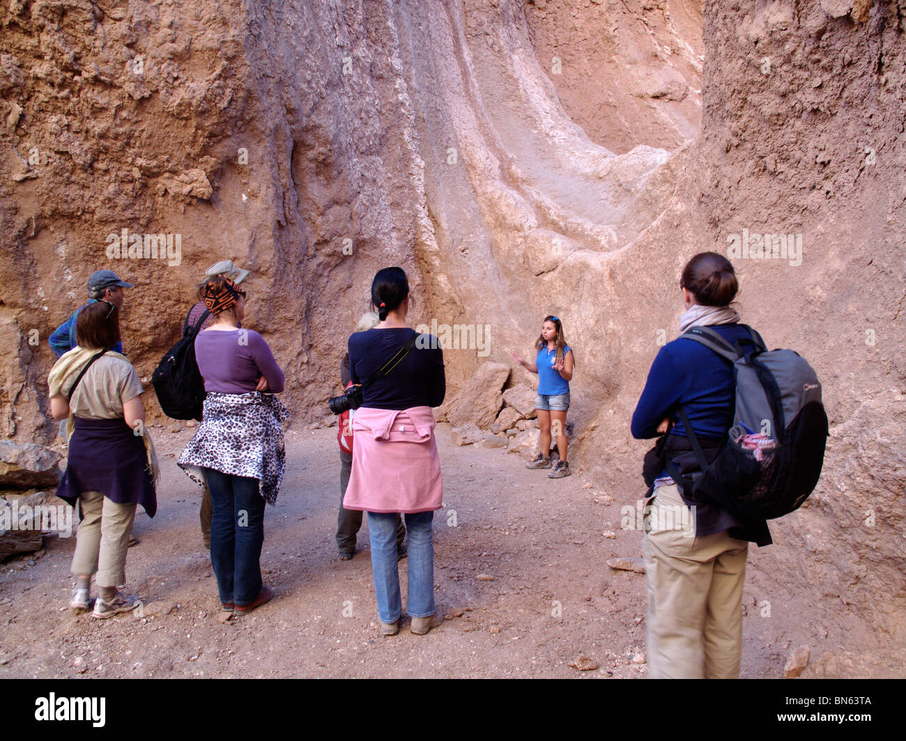 Tourists listen to a tour guide in the Valle de Luna or Mlon Valley ...