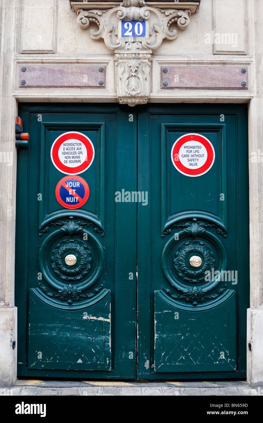 A pair of large green gates in Paris marked with the street number 20 ...